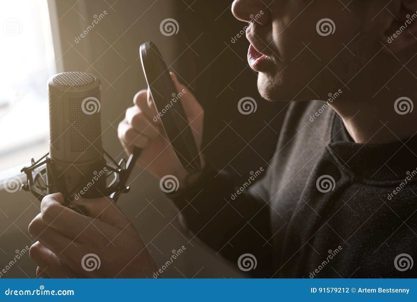 A Close-up of Lips at the Microphone of a Singing Young Man Standing in ...