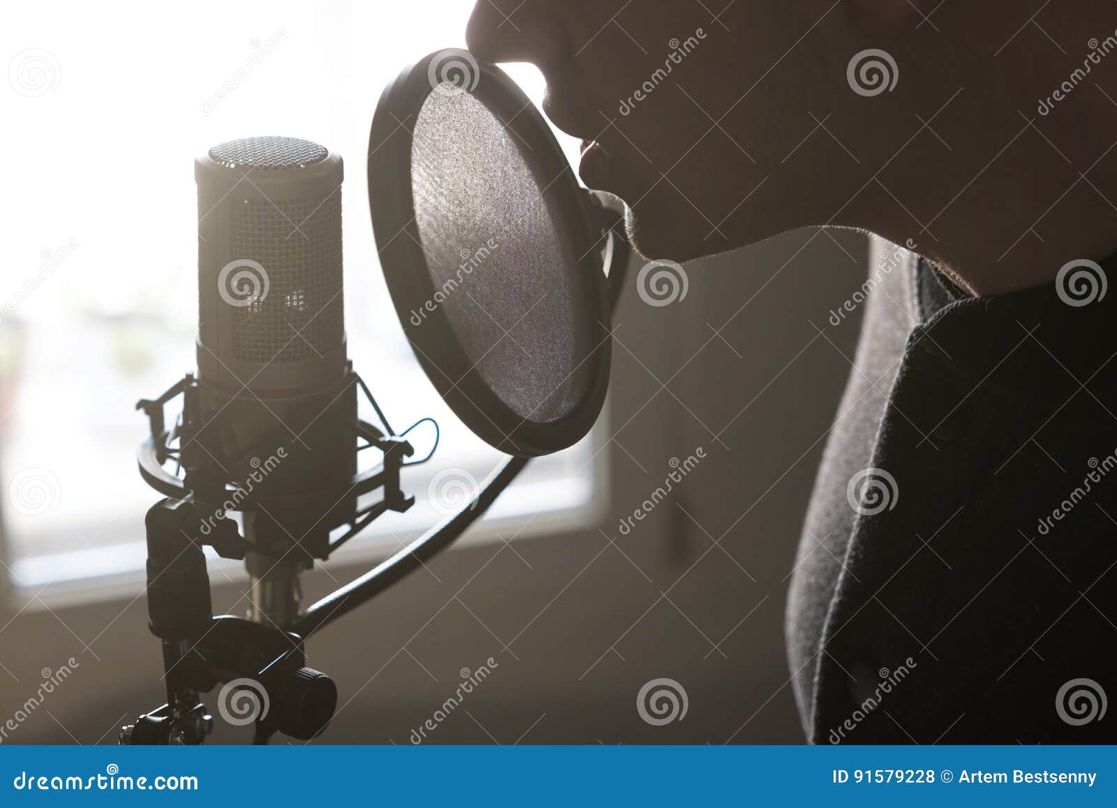 A Close-up of Lips at the Microphone of a Young Man Standing in Profile ...