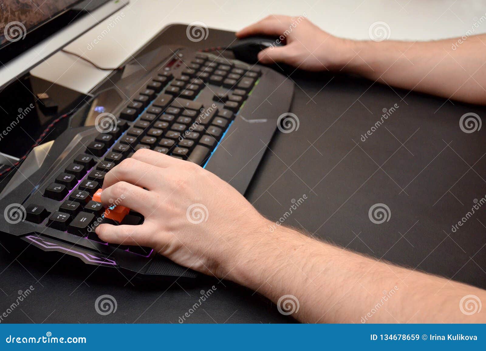 Close-up of Male Hands on a Black Gaming Keyboard with Neon Light on a ...