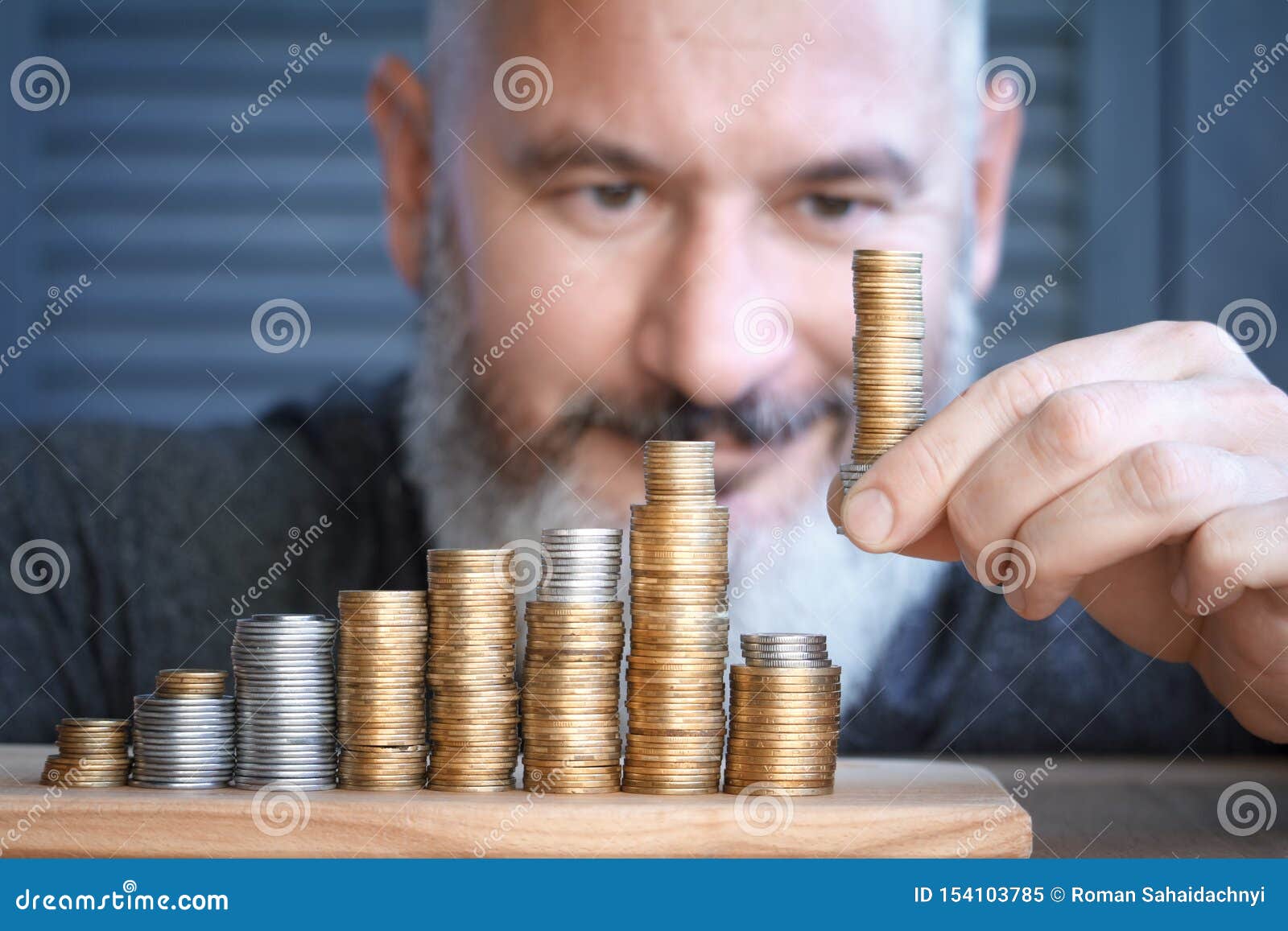 Close-up Man Collects Columns of Multi-colored Coins of Increasing ...