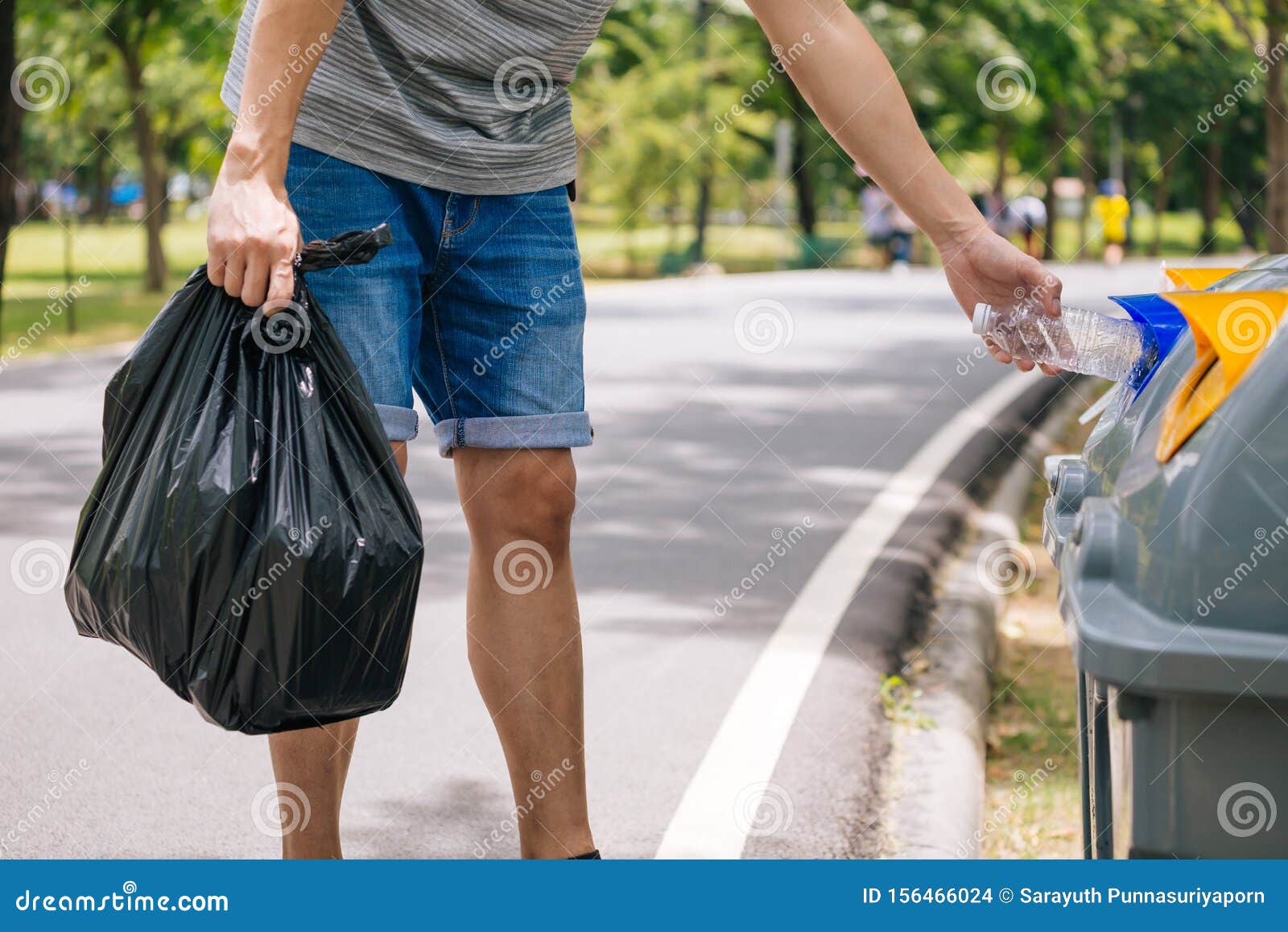 Close Up of Man Hand Throwing a Plastic Bottle into Recycle Dustbin ...