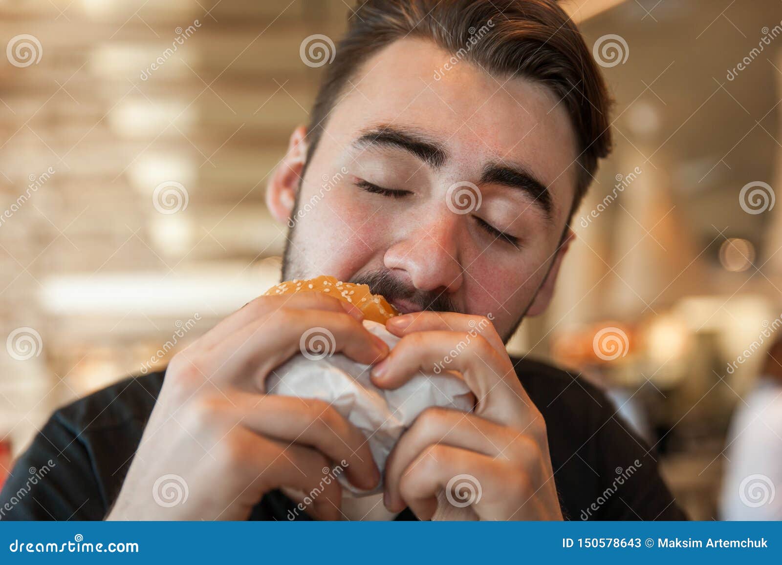 Close-up of a Man Holding a Hamburger in His Hand and Biting Stock ...