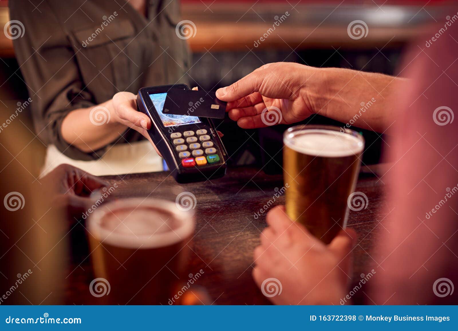 Close Up of Man Paying for Drinks at Bar Using Contactless Card Stock ...