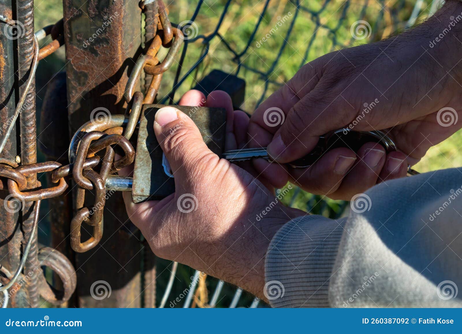 Close-up of a Man S Hands Opening the Lock in the Gate Stock Photo ...