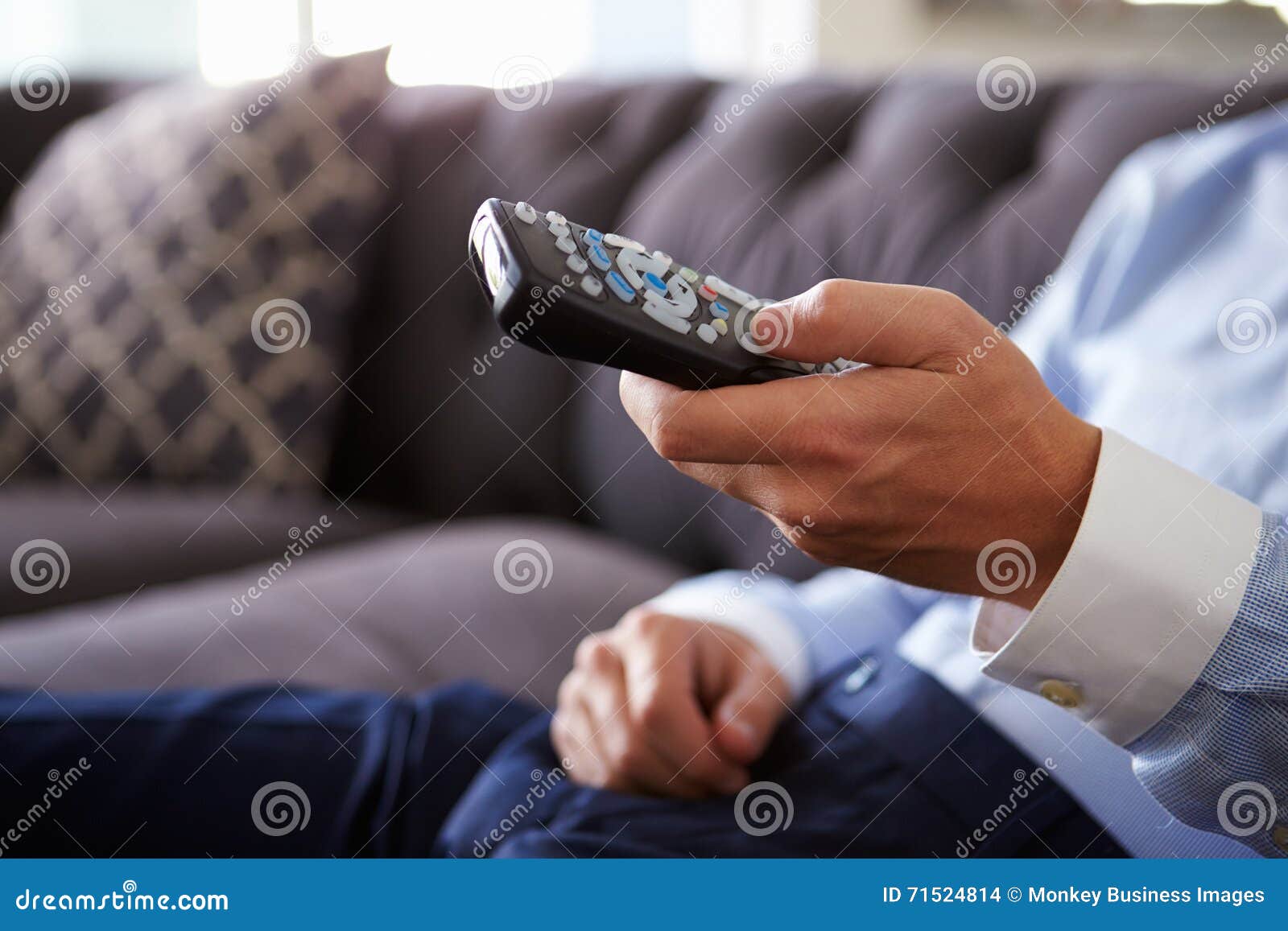 Close Up of Man Sitting on Sofa Holding TV Remote Stock Photo - Image ...