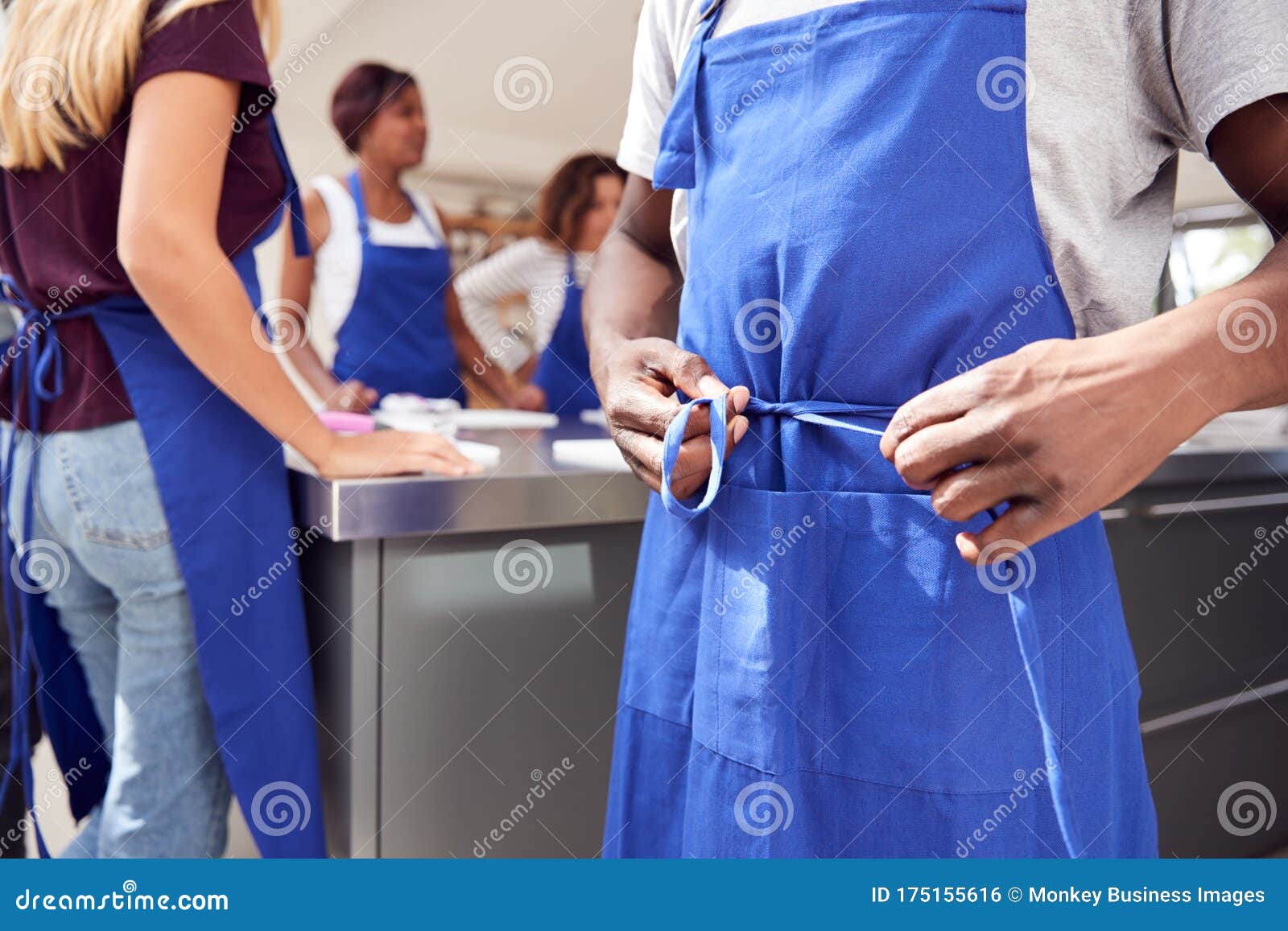 Close Up of Man Tying Apron Taking Part in Cookery Class in Kitchen ...