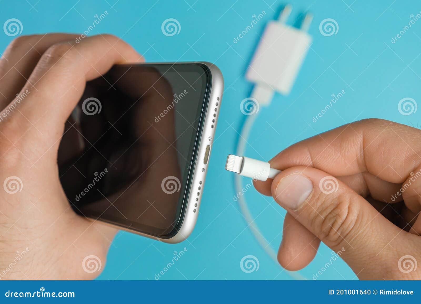 Close Up Mans Hand Inserting a Charger into the Mobile Phone through a ...
