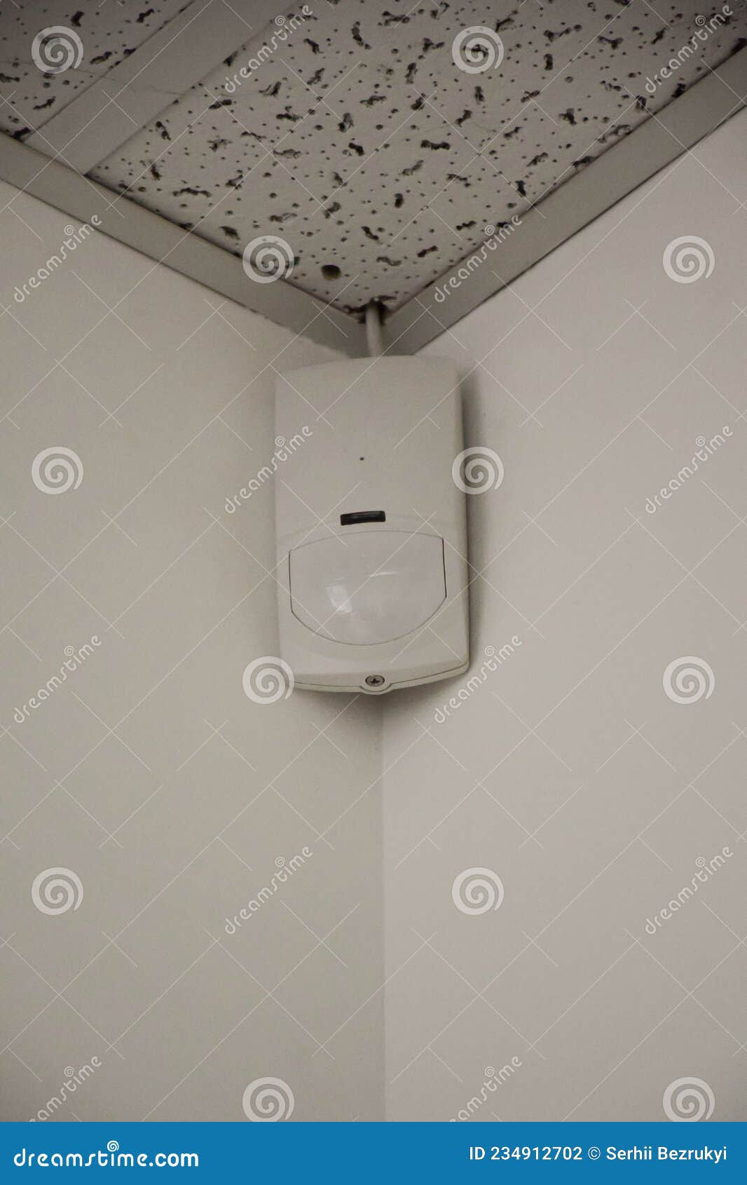 Close-up Motion Sensor in the Corner of a Living Room or Office Under a ...
