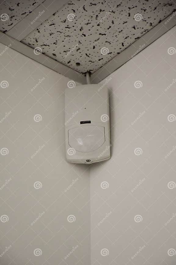 Close-up Motion Sensor in the Corner of a Living Room or Office Under a ...