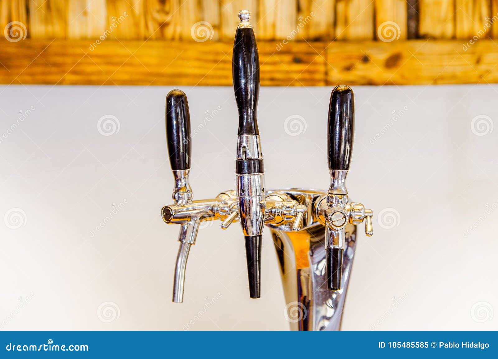 Close Up Of Multiple Beer Taps Located Over A Wooden Table In A Blurred ...