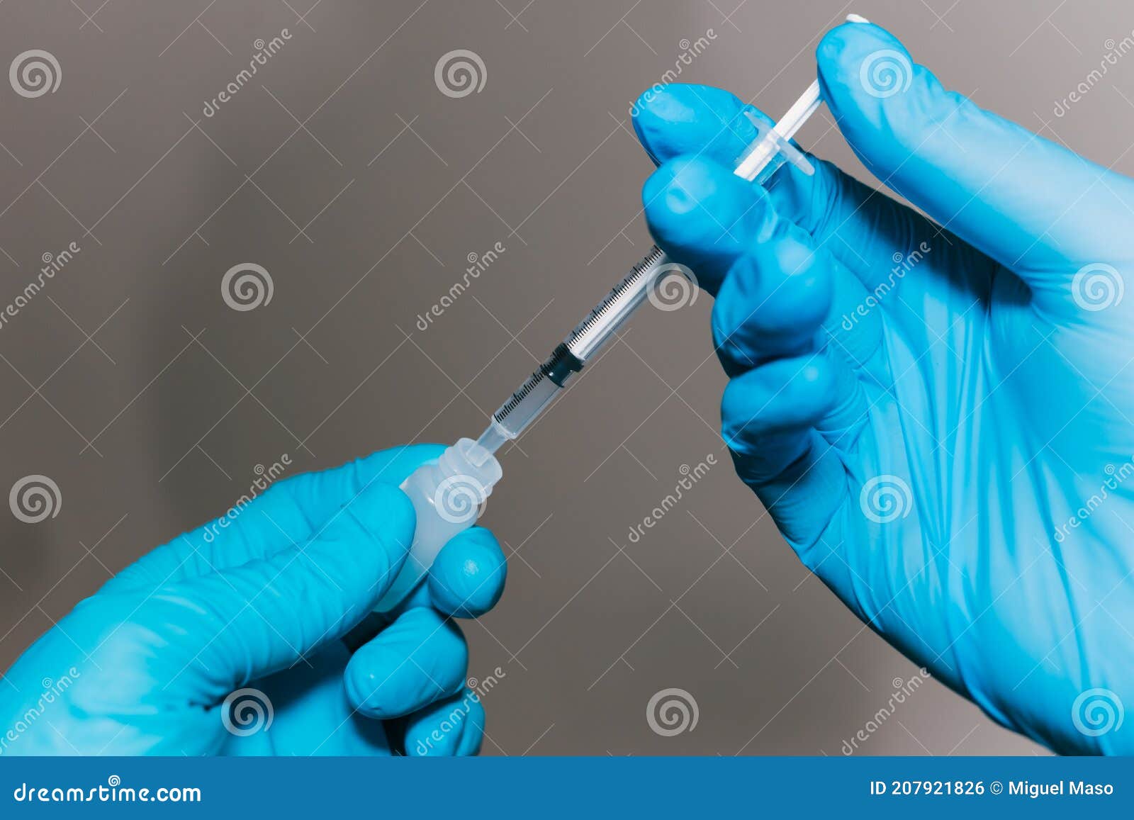 Close-up of a Nurse`s Gloved Hands Inserting a Vaccine into a Syringe ...
