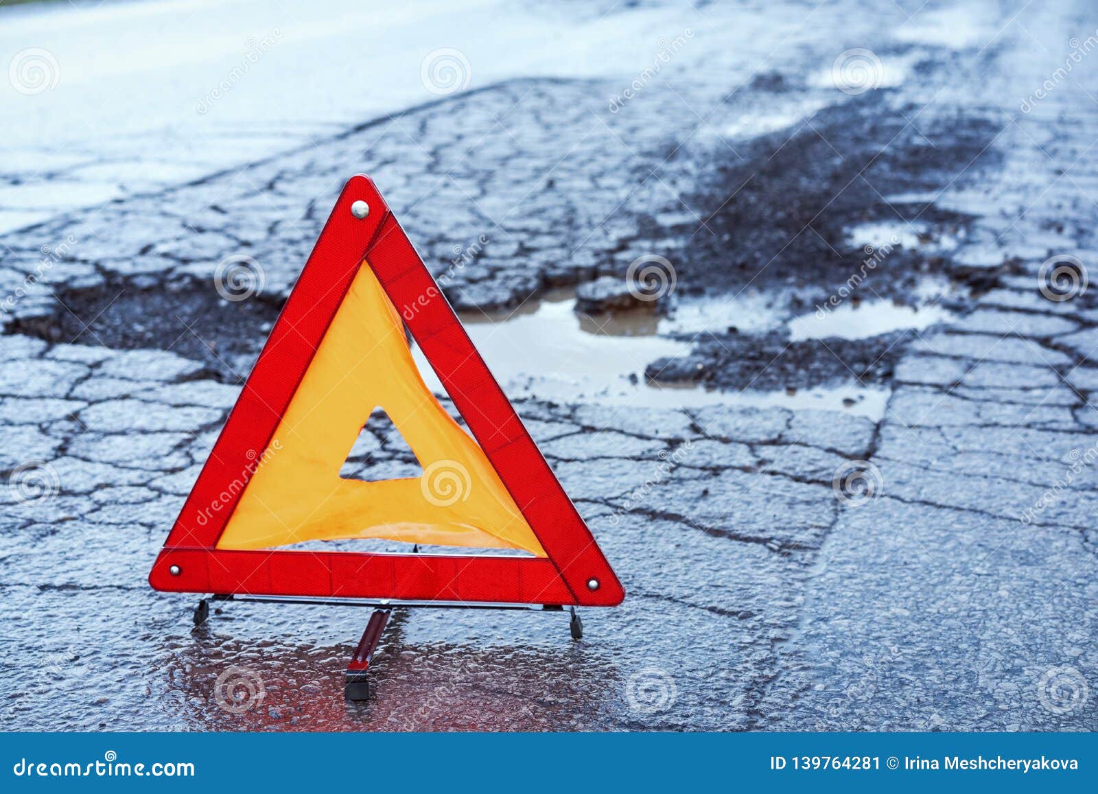 Close Up of an Orange Triangle Road Sign in the Background of a Broken ...