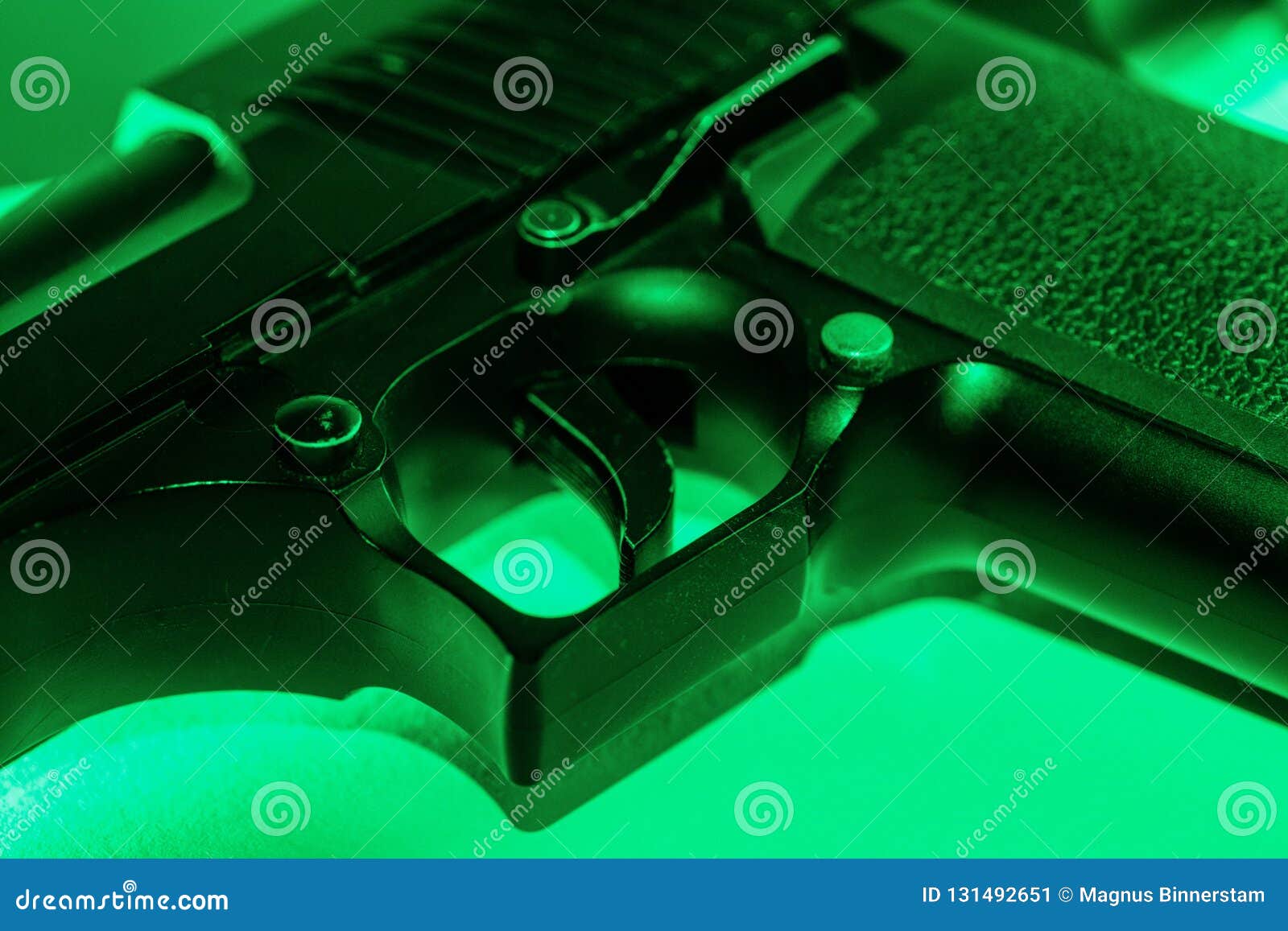 Close Up Partial View of an Automatic Hand Gun Illuminated in Green ... Close Up Partial View of an Automatic Hand Gun Illuminated in Green ...