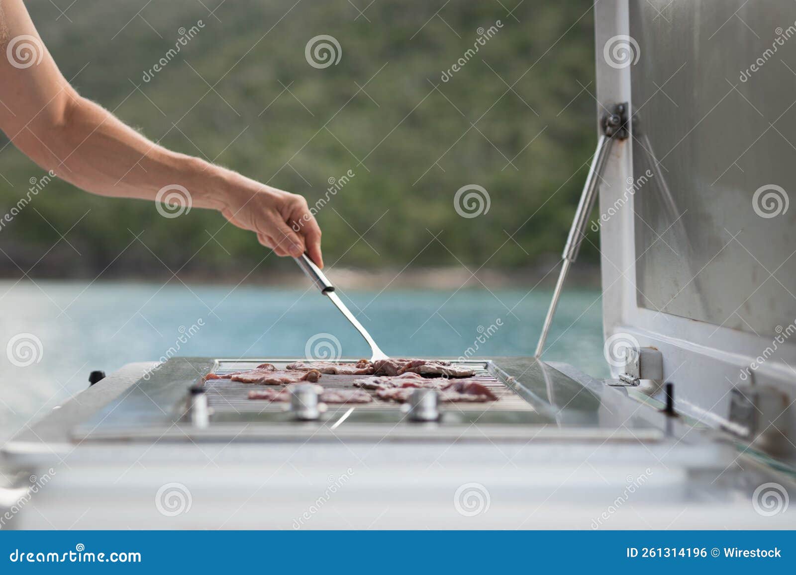 Close-up of a Person Cooking Bacon on a Grill Outside in Front of the ...