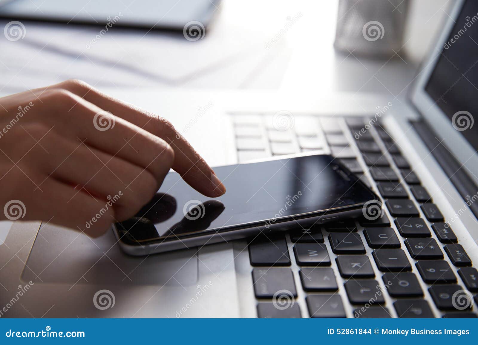 Close Up of Person at Laptop Using Mobile Phone Stock Photo - Image of ...