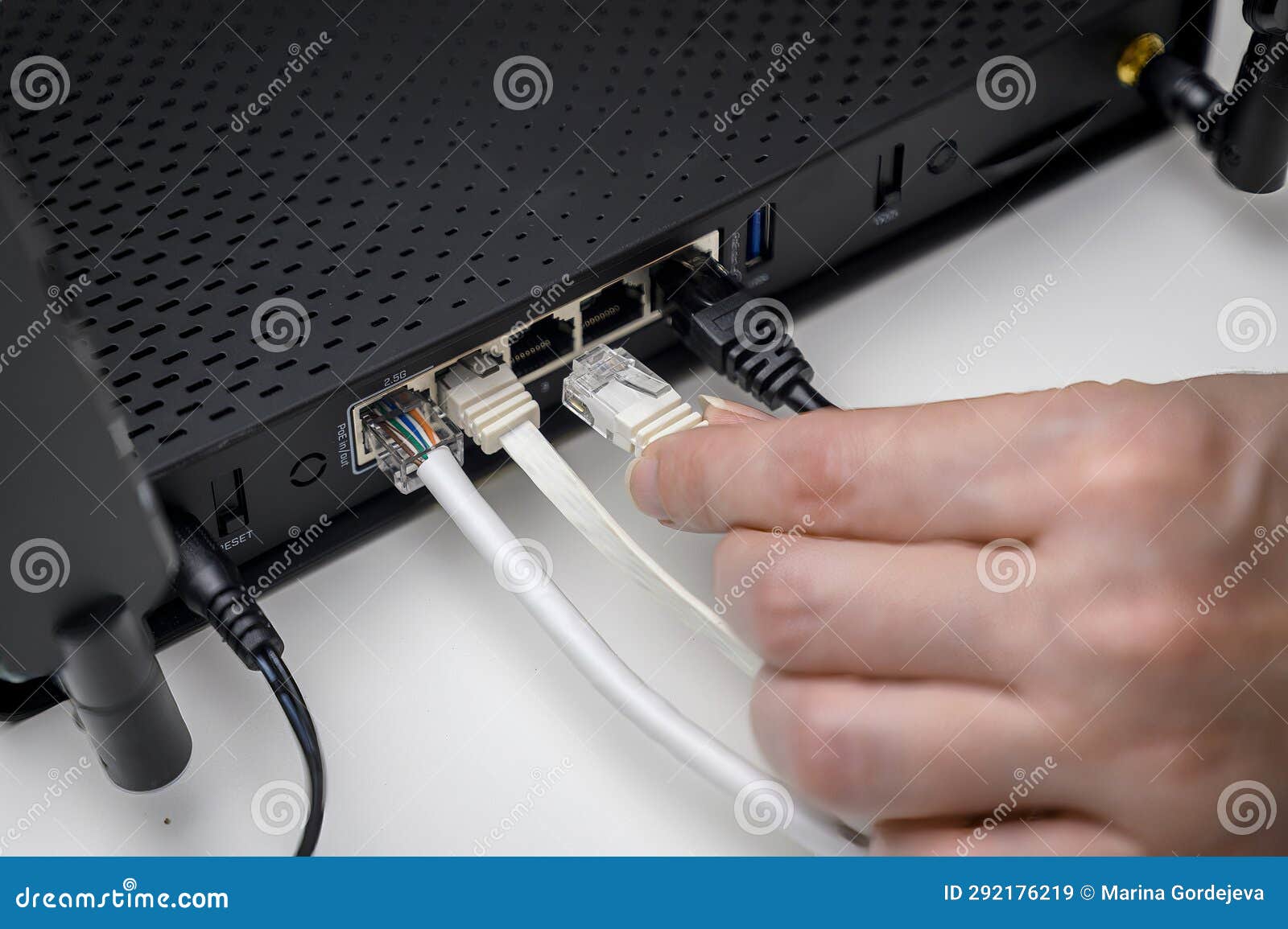 A Close Up of a Person Plugging Wires into a Router. a Person Connects ...