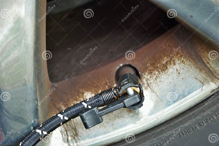Close Up of a Portable Air Compressor Connected To the Valve Stem of a ... Close Up of a Portable Air Compressor Connected To the Valve Stem of a ...