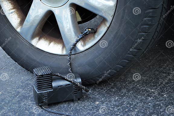 Close Up of a Portable Air Compressor Connected To the Valve Stem of a ... Close Up of a Portable Air Compressor Connected To the Valve Stem of a ...
