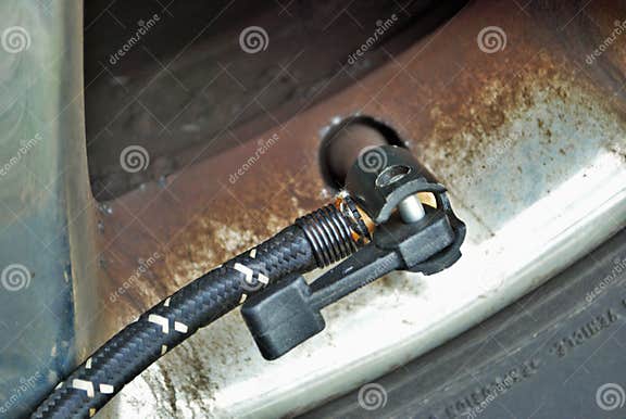 Close Up of a Portable Air Compressor Connected To the Valve Stem of a ... Close Up of a Portable Air Compressor Connected To the Valve Stem of a ...