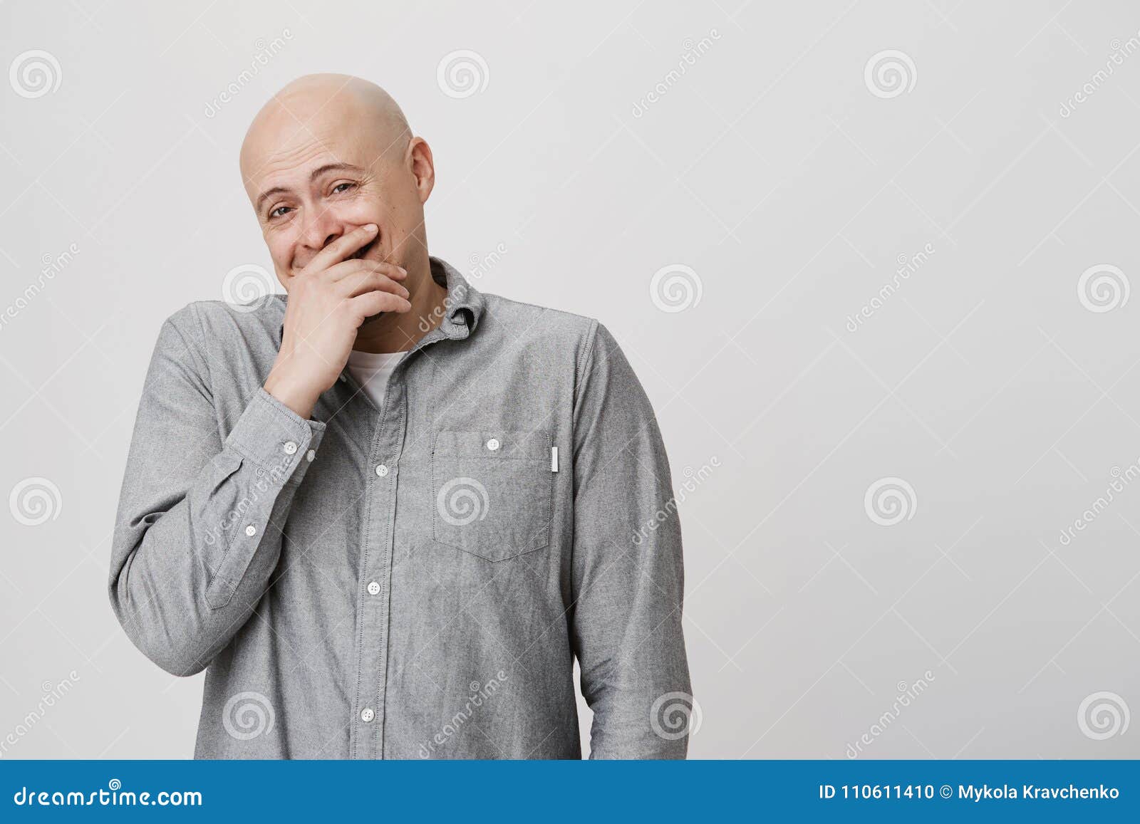 Close Up Portrait Of Bald Man Laughing And Covering His Mouth With Hand