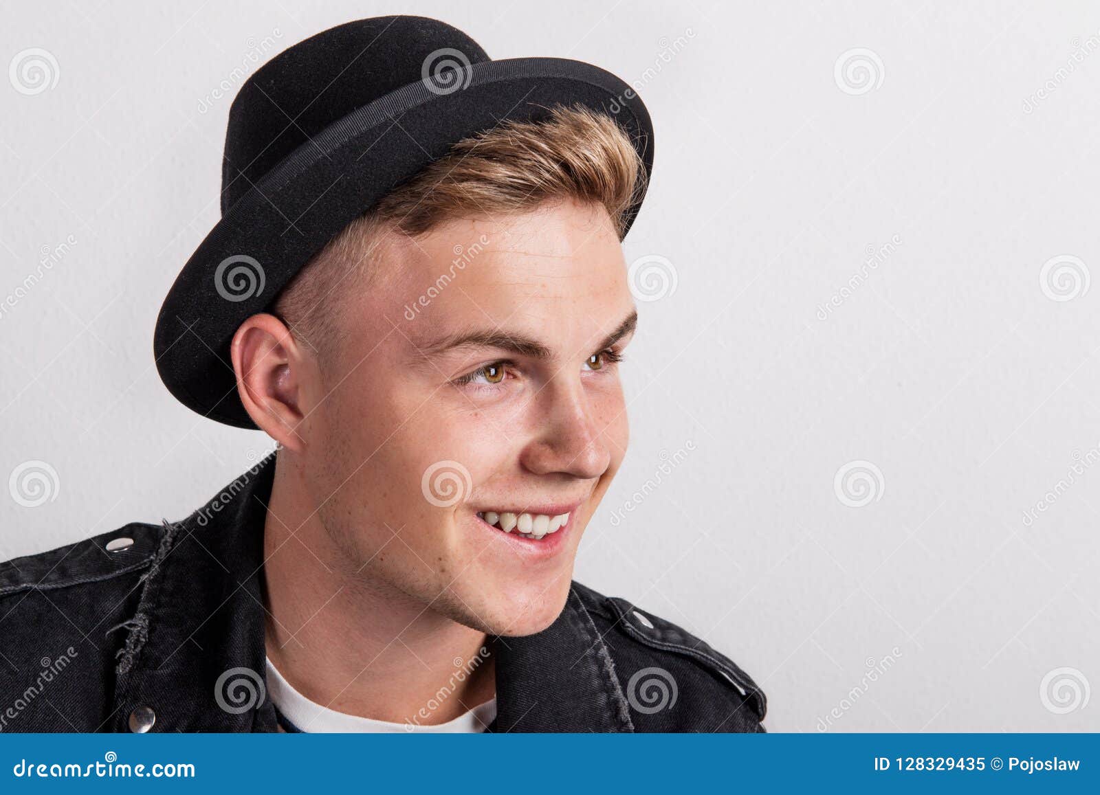 Close-up Portrait of a Confident Young Man with a Black Hat in a Studio ...