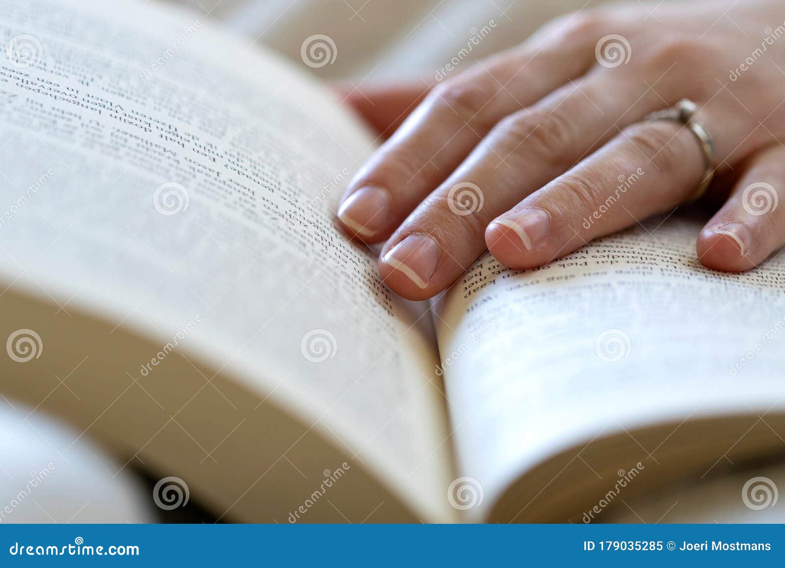A Close Up Portrait Of A Hand Of A Person Touching The Page In A Book