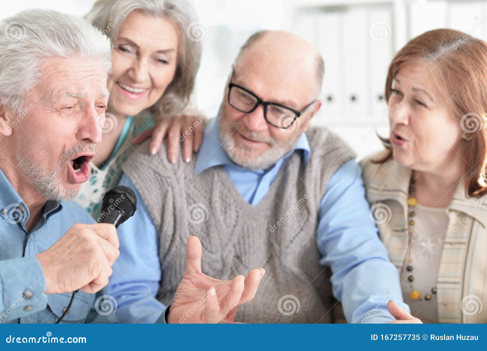 Close Up Portrait of Two Senior Couples Singing Karaoke with Microphone ...