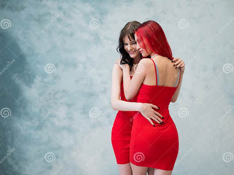 A Close Up Portrait Of Two Tenderly Embracing Women Dressed In