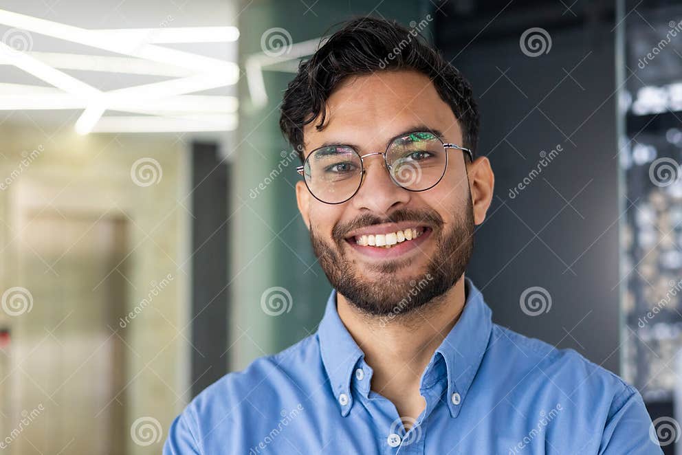 Close Up Portrait Of A Young Indian Man Standing In Glasses And Blue