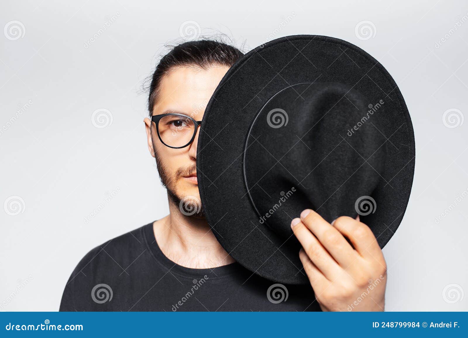 Close-up Portrait of Young Man Hides Half Face with Black Hat on White ...