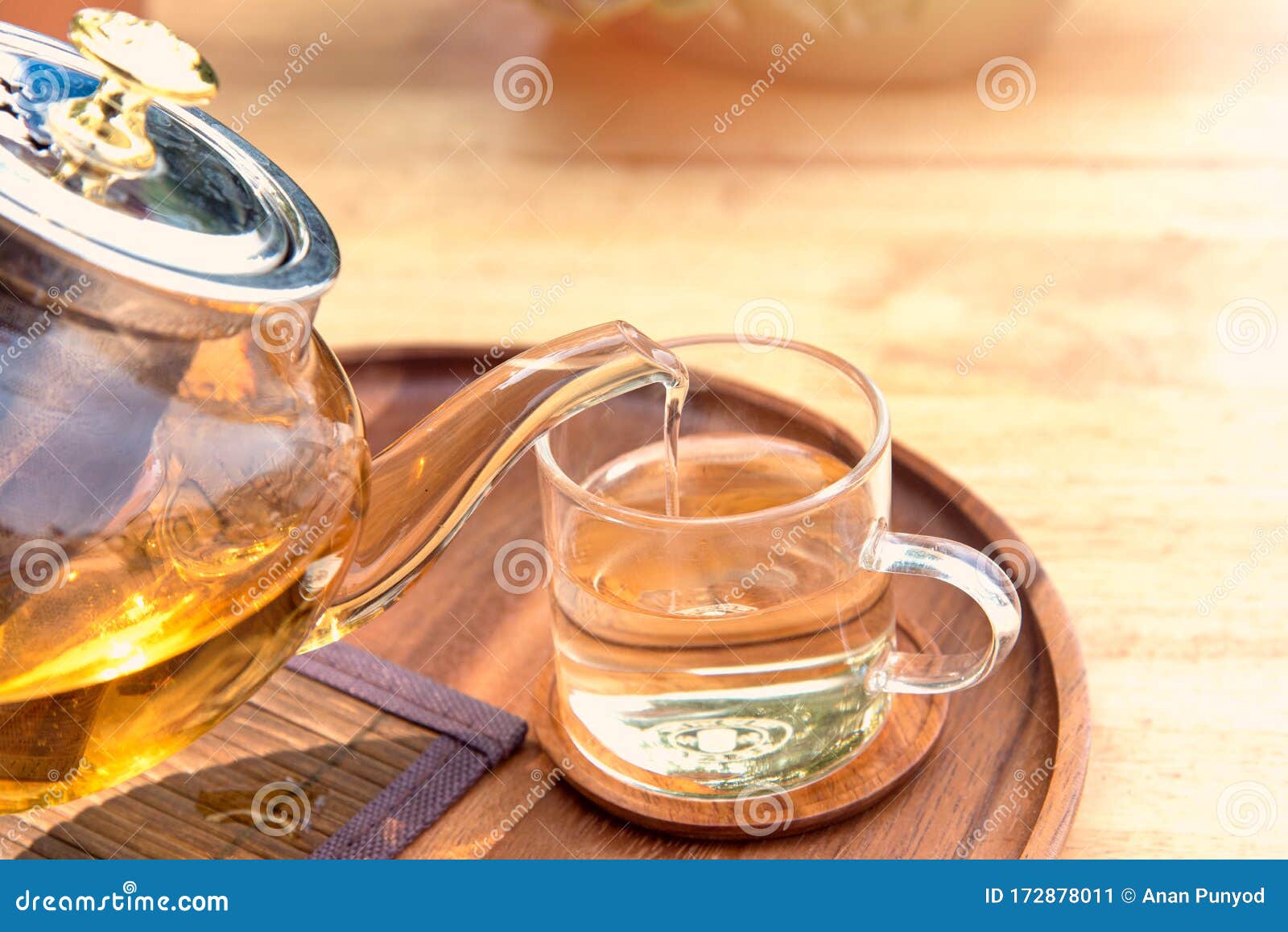 Close Up Pour the Tea from the Kettle into a Cup of Tea on the Table ...