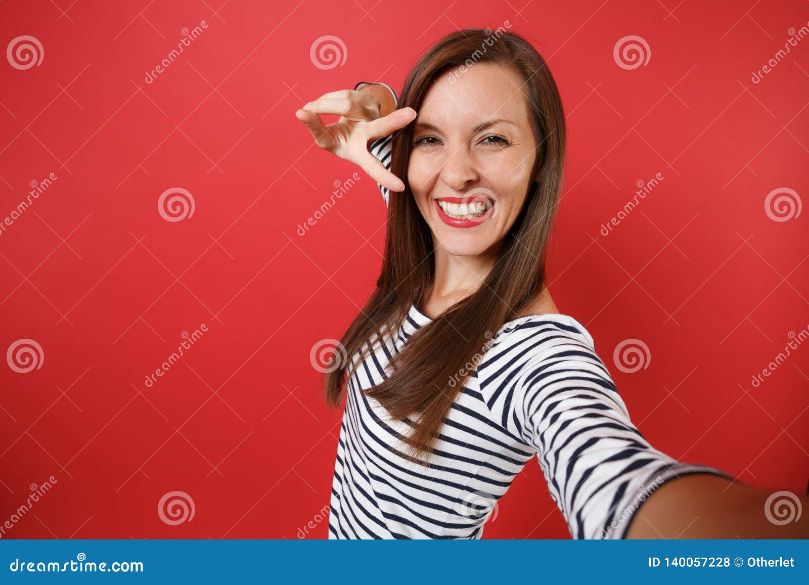 Close Up Selfie Shot Of Smiling Joyful Young Woman In Casual Striped