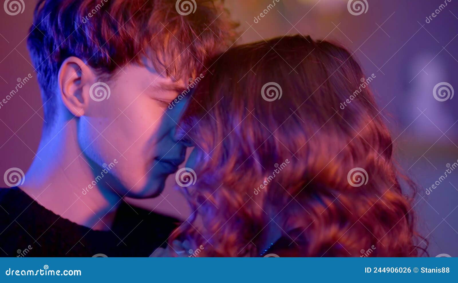 Close Up Of A Sensual Couple Flirting Kissing Under Neon Lights In A