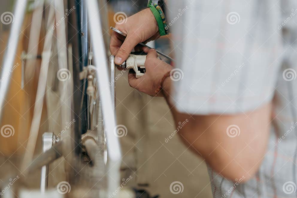 Close Up of Serviceman Repairing Modern Bike Using Special Tool while ... Close Up of Serviceman Repairing Modern Bike Using Special Tool while ...