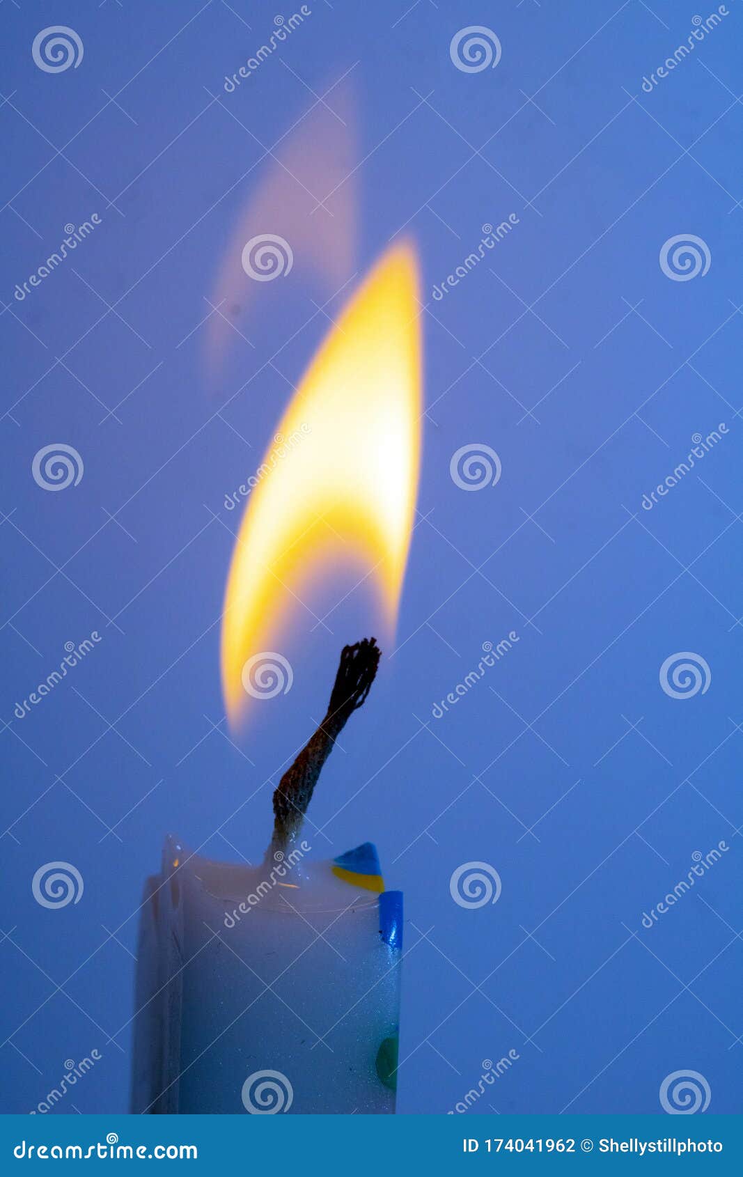 A Close Up of a Single Candle Flame and Wick on Coloured Background ...