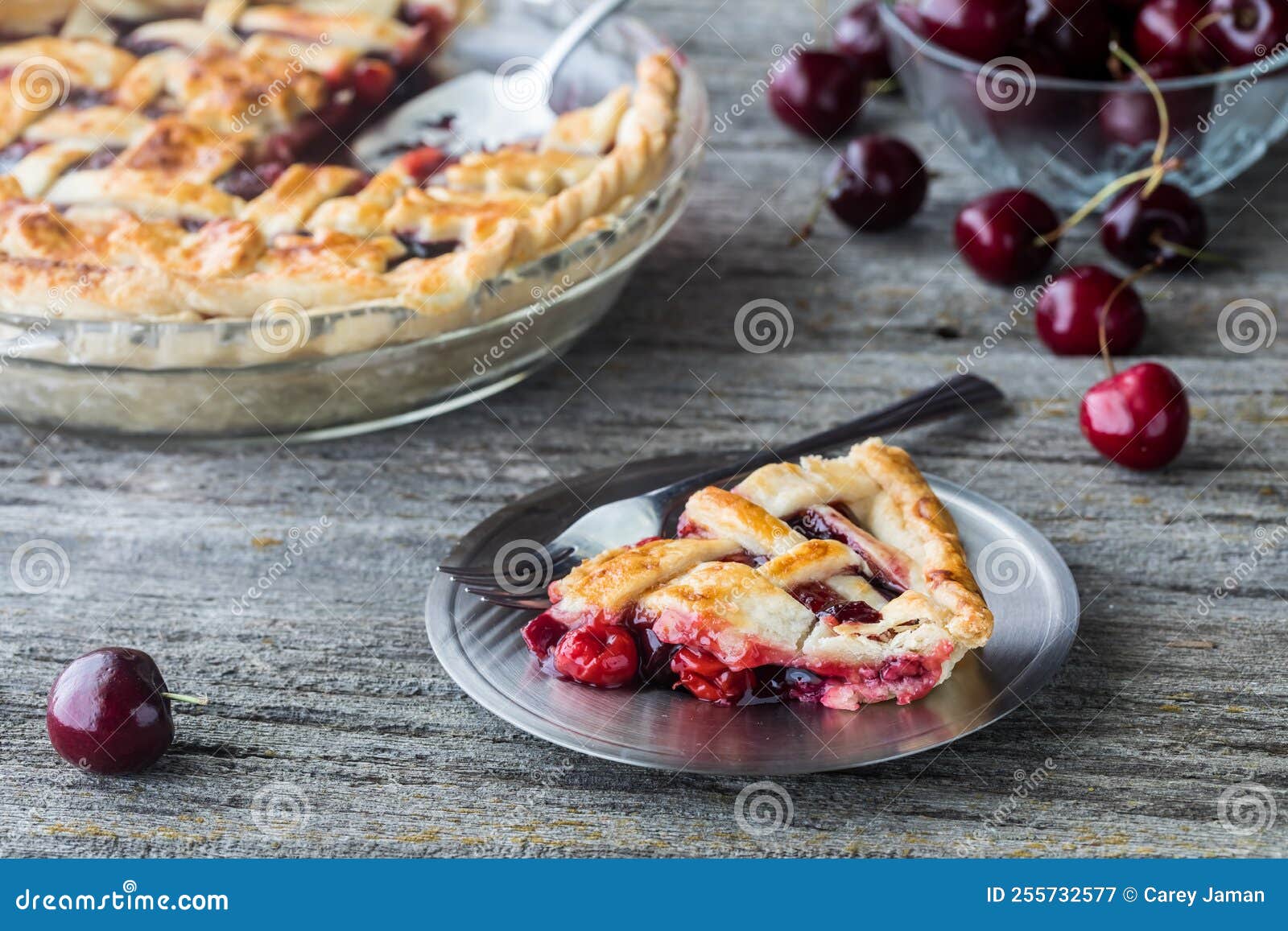 A Close Up of a Slice of Cherry Pie with the Rest of the Pie in Behind ...
