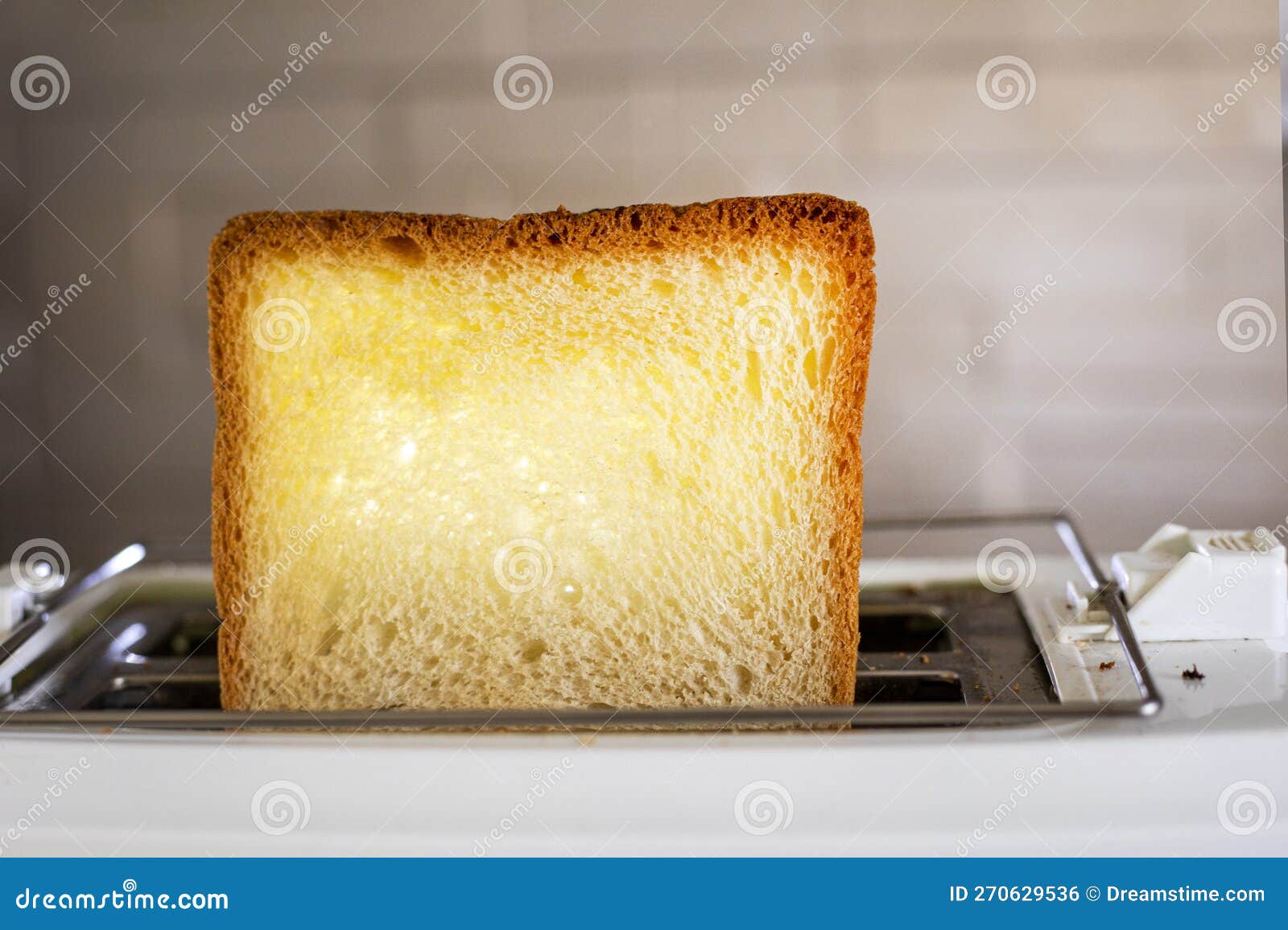 Close-up of a Slice of Toasted White Bread in a Toaster in the Kitchen ...
