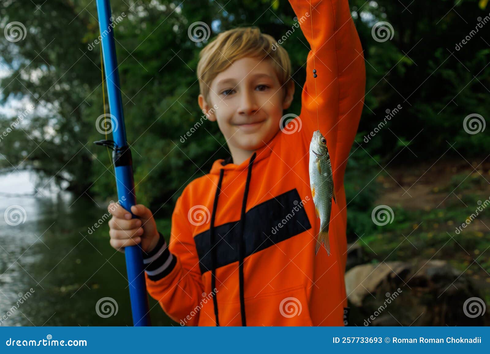 Close-up of a Small Fish on a Hook that the Boy Caught and Holds in ...