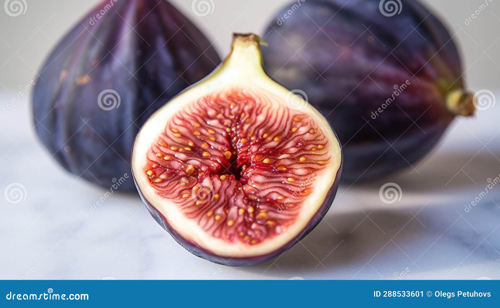 A Close Up of Some Figs on a White Table with One Cut in Half and the ...