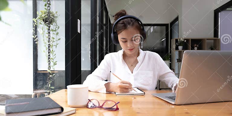 Close Up of Student Learning Online Class by Using Laptop Computer and Writing Notebook at ...