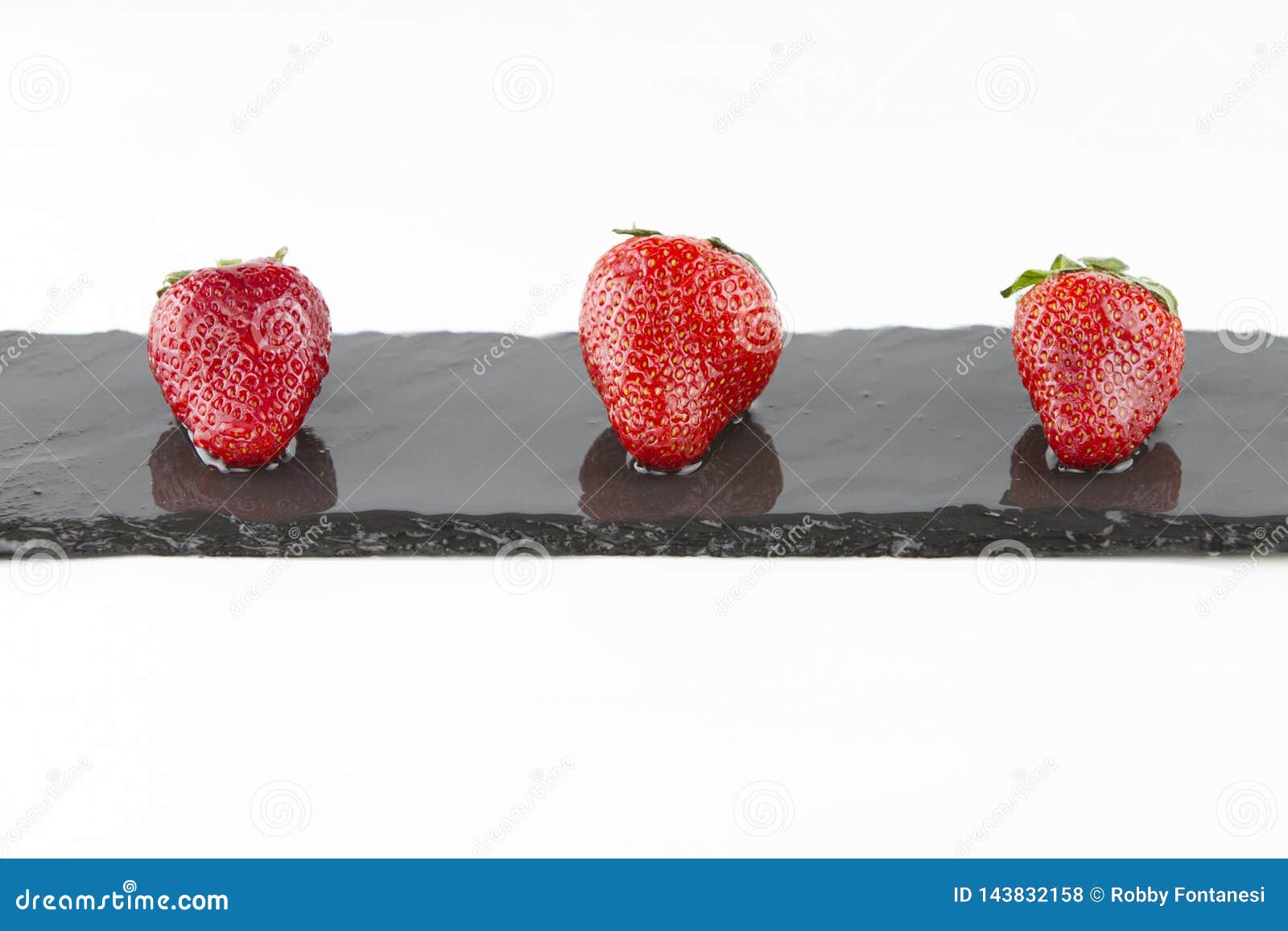 Close-up of Three Isolated Strawberries on a Rectangular Strip of Wet ...