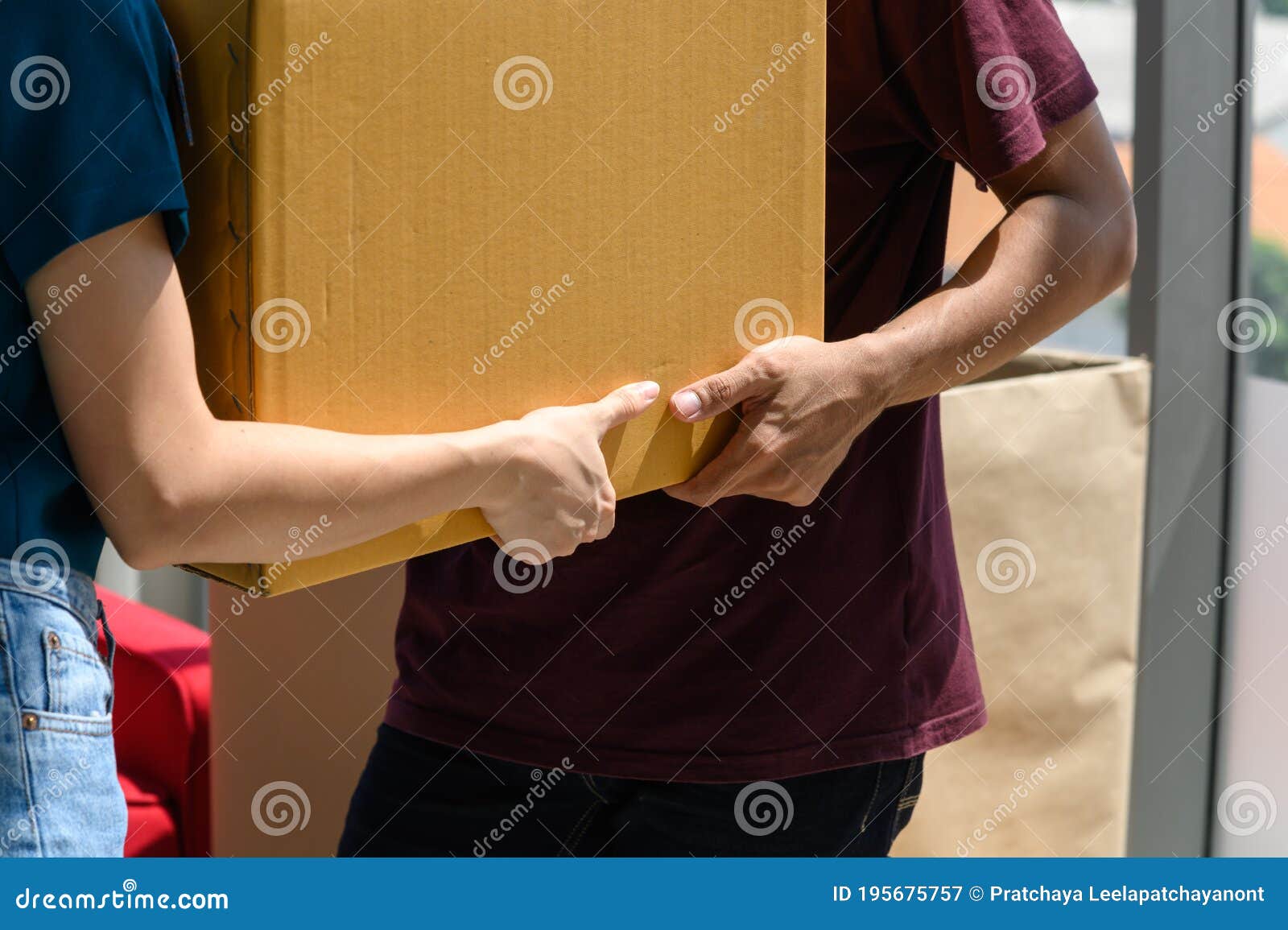 Close Up To Hand Of Young Asian Couple When They Carrying Big Cardboard