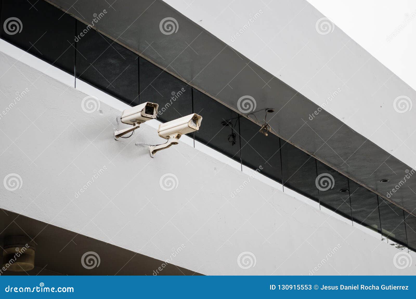 Close Up To Two Security Cameras on the Structure of a Building with a ...