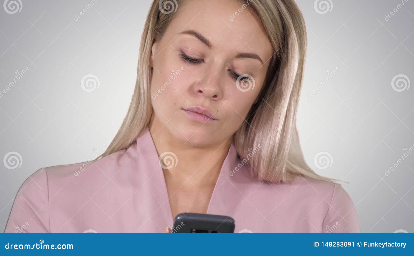 Trendy Smiling Blond Woman Using Her Mobile Phone Smiling As She Types