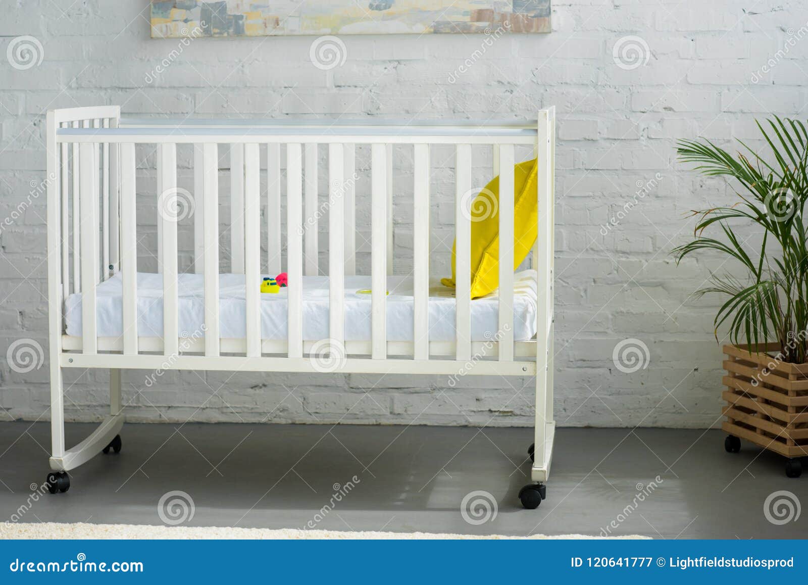 Close Up View of Empty Baby Crib with Yellow Pillow Stock Image - Image ...
