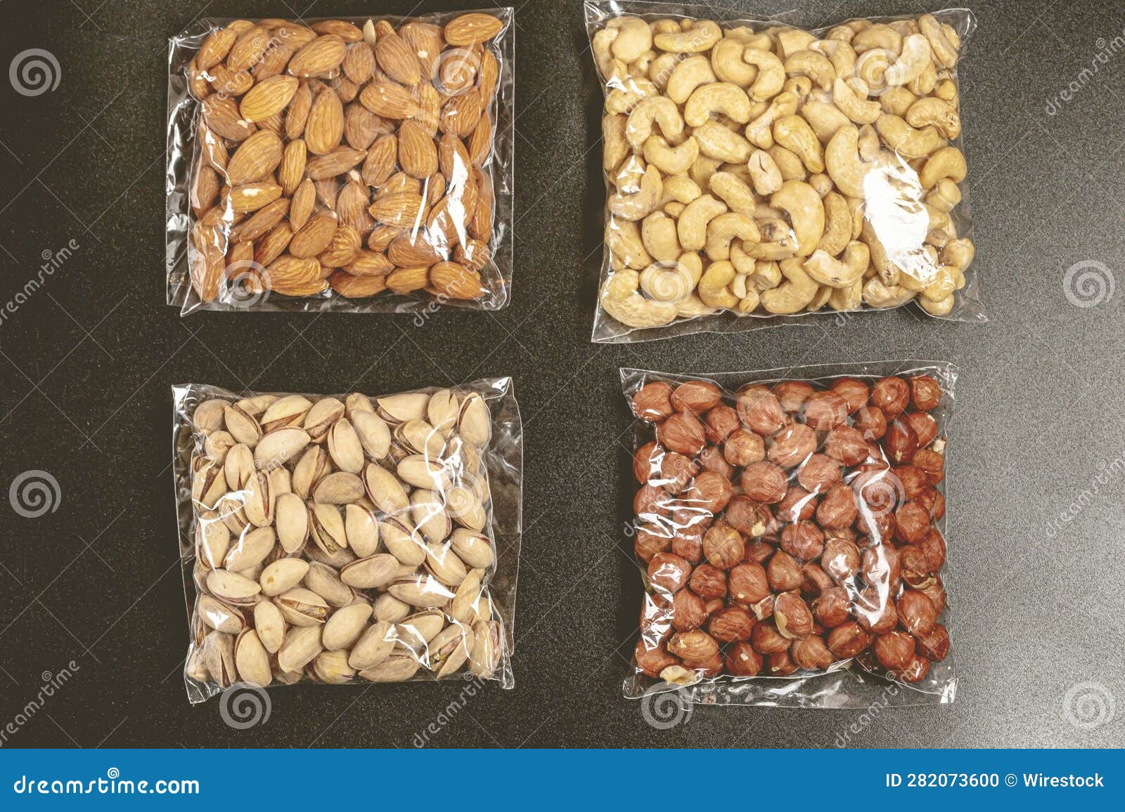 Four Packages Filled with Different Nuts and Peanuts on Top of a Table ...