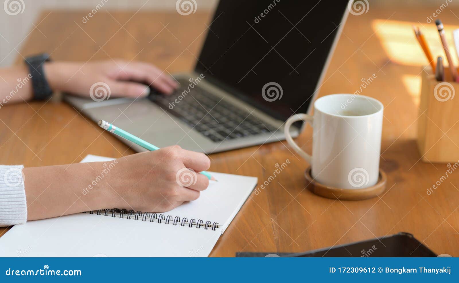 Close-up View of Student Taking Notes on Her Exam while Using Laptop ...
