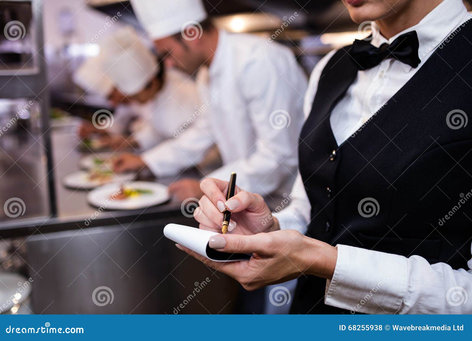 Close-up of Waitress with Note Pad in Commercial Kitchen Stock Photo ...