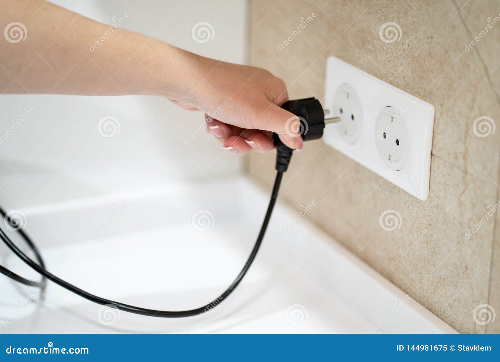 Close Up Woman Hand Insert or Pull Out Elecrticity Plug in Outlet on ...