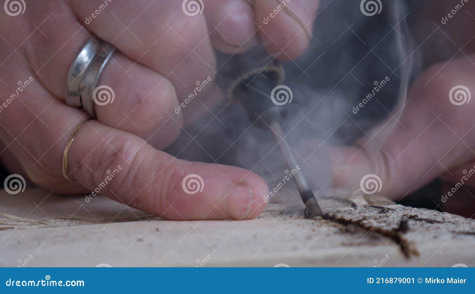 Close-up of Worker`s Hand with Tools Hacking Wood with Smoke that is ...